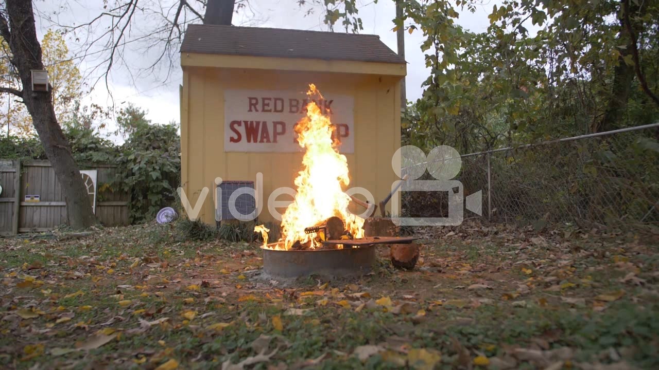 man throws flaming rag on gasoline soaked wood to start fire slow ...